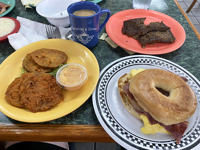 A breakfast spread that speaks the universal language of "good morning" – fried tomatoes, breakfast sandwich, and meatloaf that doesn't care what time it is.