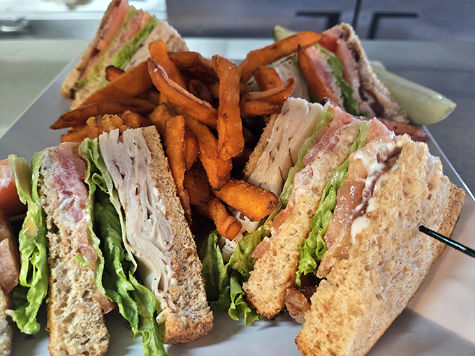 A club sandwich that stands tall and proud, like the architectural achievement it truly is. Those sweet potato fries deserve their own fan club.