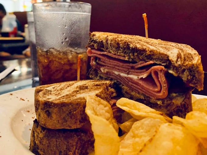 This turkey pastrami sandwich isn't messing around—layers stacked higher than your unread emails, with chips standing guard against hunger.