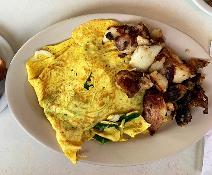 This isn't just an omelet—it's an edible love letter to breakfast. Folded with the precision of origami and paired with home fries that demand attention.