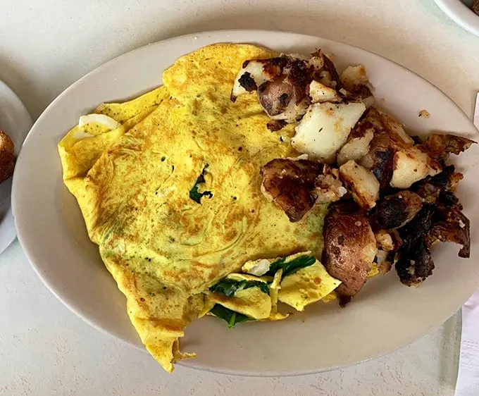 This isn't just an omelet—it's an edible love letter to breakfast. Folded with the precision of origami and paired with home fries that demand attention.