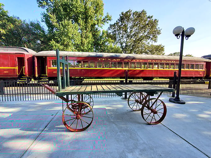 The vintage luggage cart waits patiently by the platform, a humble reminder of when travel involved steamer trunks instead of rolling suitcases.