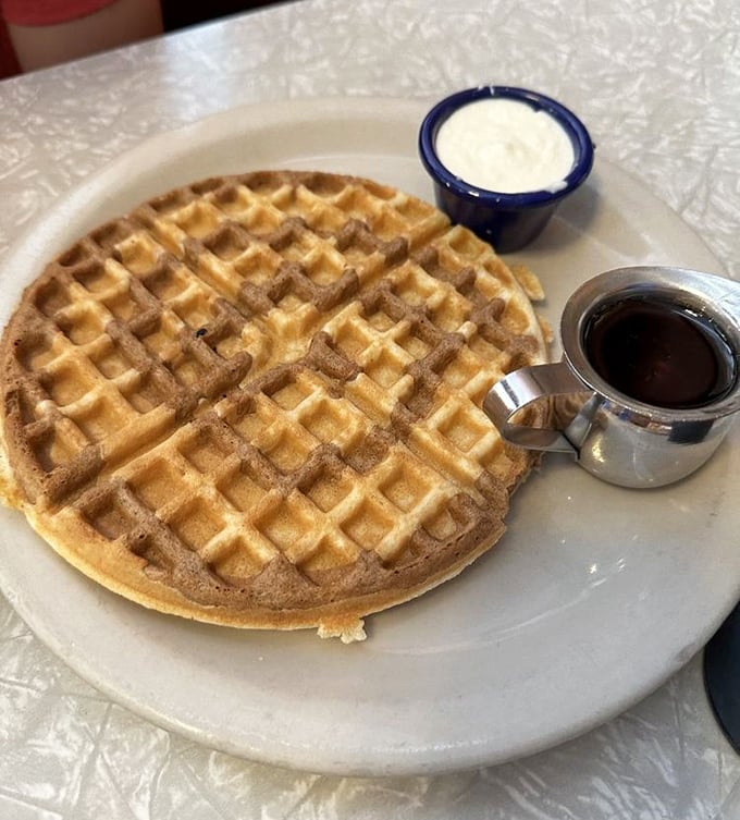 This golden waffle isn't just breakfast—it's an edible sunburst on a plate, complete with butter melting into each perfect square.