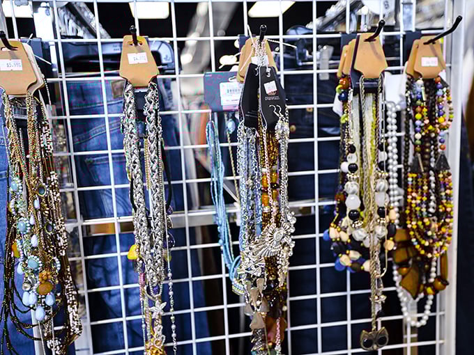 A rainbow of necklaces dangles with possibility. One person's forgotten accessory becomes another's statement piece—that's thrift store magic.