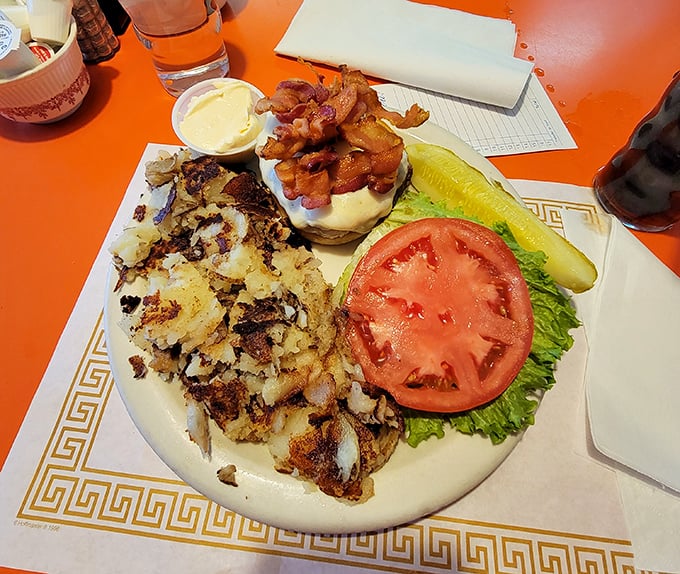 A burger that requires both hands and a strategy—crispy hash browns on the side aren't just accompaniments, they're accomplices in deliciousness.