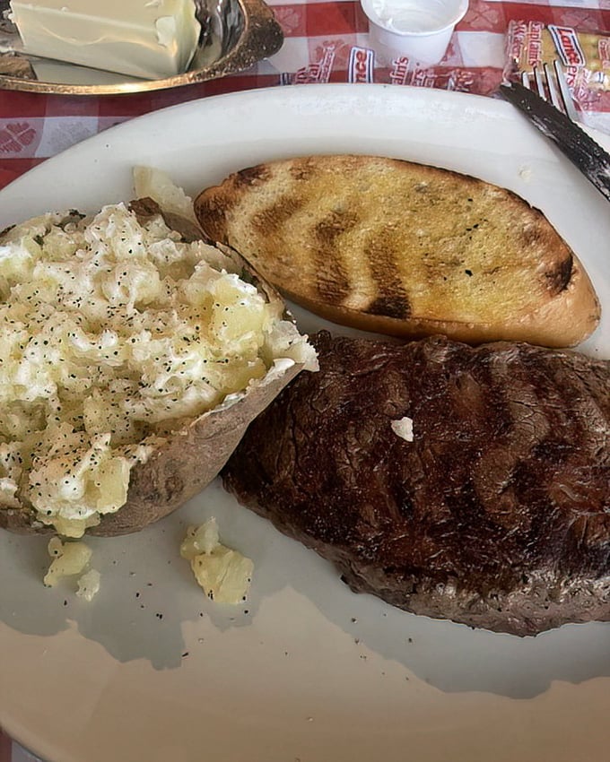 The loaded baked potato isn't just a side dish—it's a supporting actor deserving its own award, complementing the star ribeye in this meaty masterpiece.