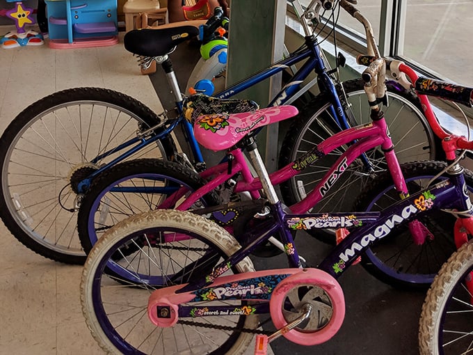 A colorful fleet of kids' bikes stands ready for new adventures, their previous memories wiped clean and waiting for fresh scraped knees and neighborhood explorations.