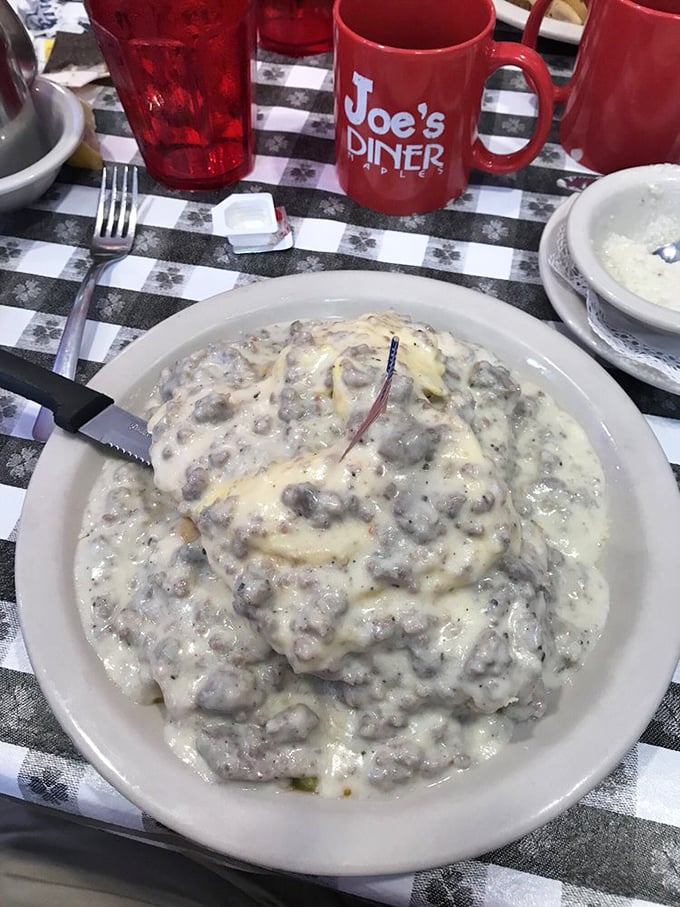 Behold the star attraction: biscuits drowning happily in a sea of peppery sausage gravy. That tiny American flag isn't patriotic—it's marking buried treasure.