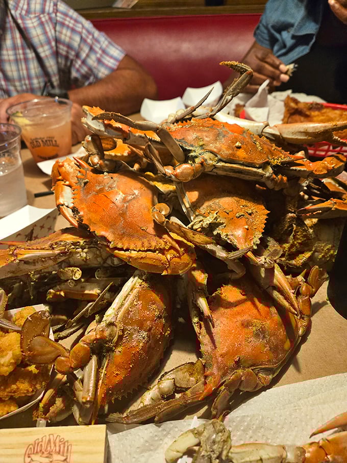 Blue crabs piled high on brown paper—this isn't just dinner, it's an event where the reward for your picking efforts is sweet, delicate meat.