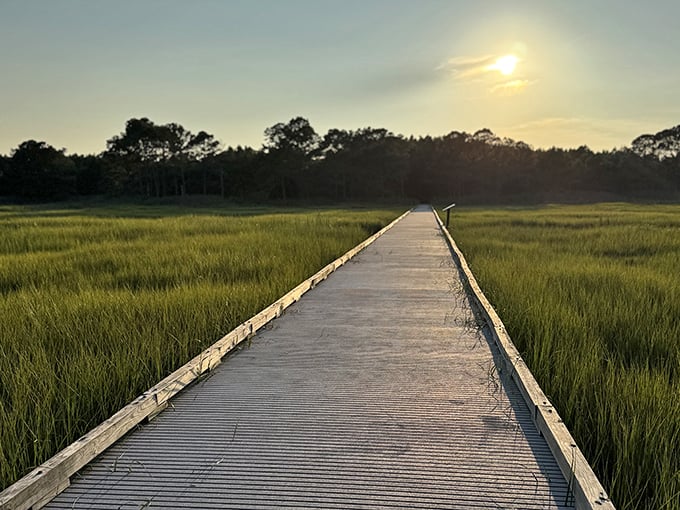A boardwalk through emerald marshlands leads to sunset views that redefine "picture perfect."