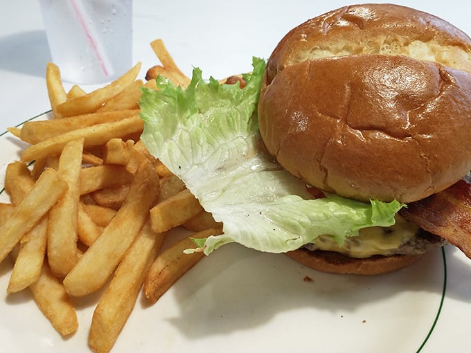This isn't just a burger—it's architecture. The golden brioche, the precise lettuce-to-patty ratio, and those fries standing at attention.