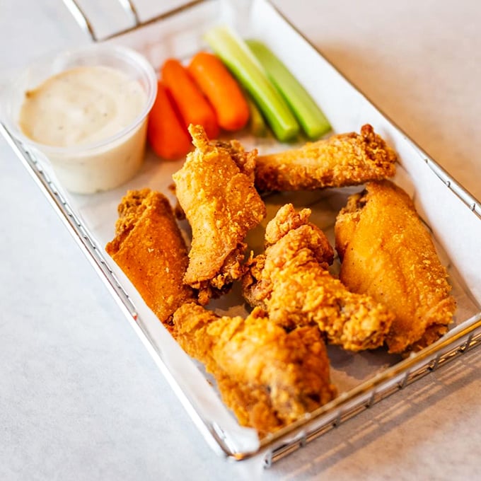 Golden-fried chicken wings that could make a seafood restaurant jealous—crispy on the outside, juicy within, and served with fresh veggies.
