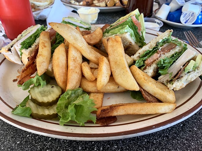 Behold the famous club sandwich in all its triple-decker glory, surrounded by fries so perfectly golden they deserve their own California postal code.