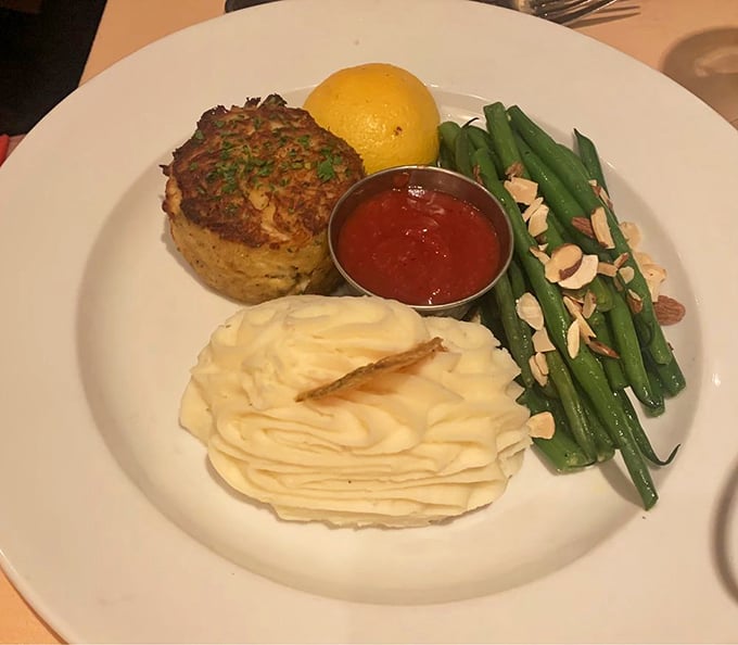 Maryland crabcake that's all crab and no filler, served with whipped potatoes and green beans—proof that sometimes the simplest presentations showcase the finest ingredients.