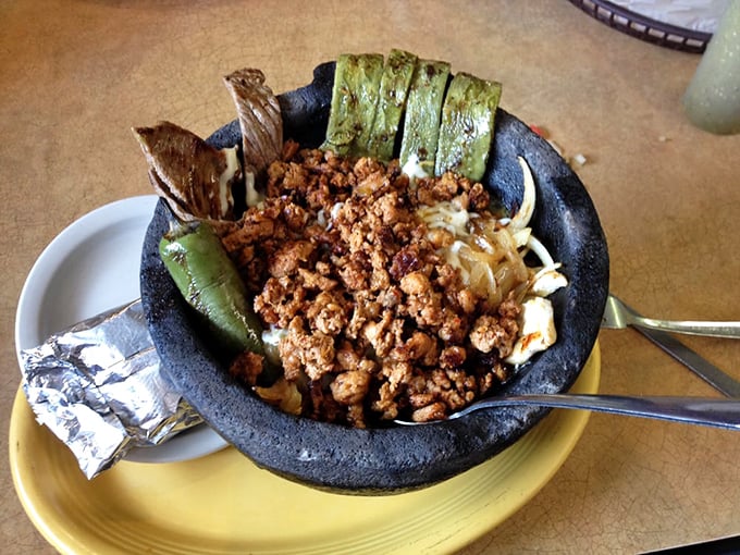 El molcajete arrives like a volcanic eruption of flavor—the traditional stone bowl keeping everything sizzling hot while you contemplate where to dive in first.