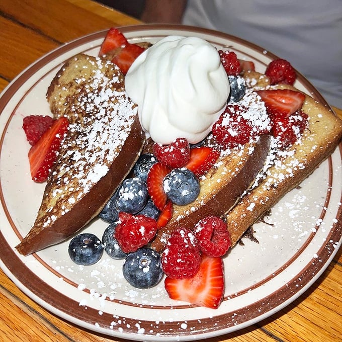 This French toast doesn't just have berries—it has a berry entourage, complete with powdered sugar snowfall and whipped cream mountains.