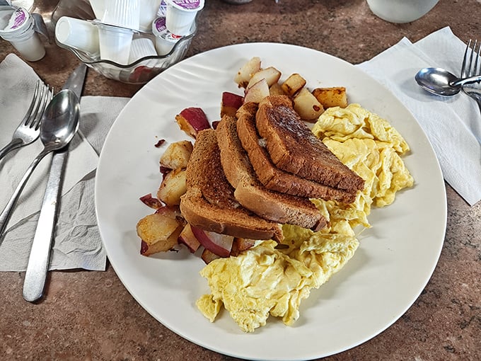 The breakfast trinity—golden eggs, perfectly browned toast, and home fries with that ideal crisp-tender balance—simple perfection that needs no Instagram filter.