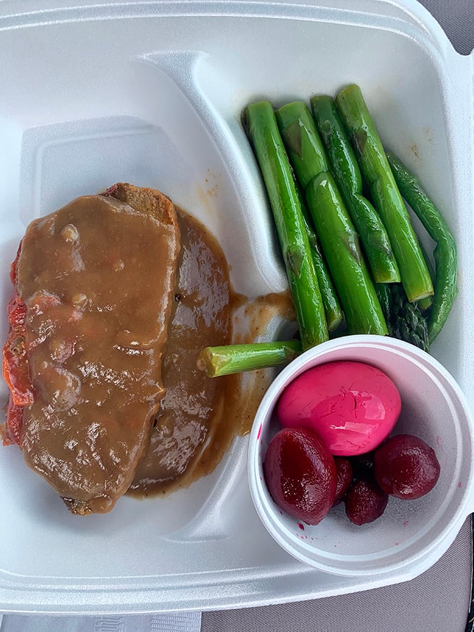 Meatloaf smothered in gravy alongside asparagus and pickled beets—the holy trinity of Pennsylvania Dutch comfort on a takeout tray.
