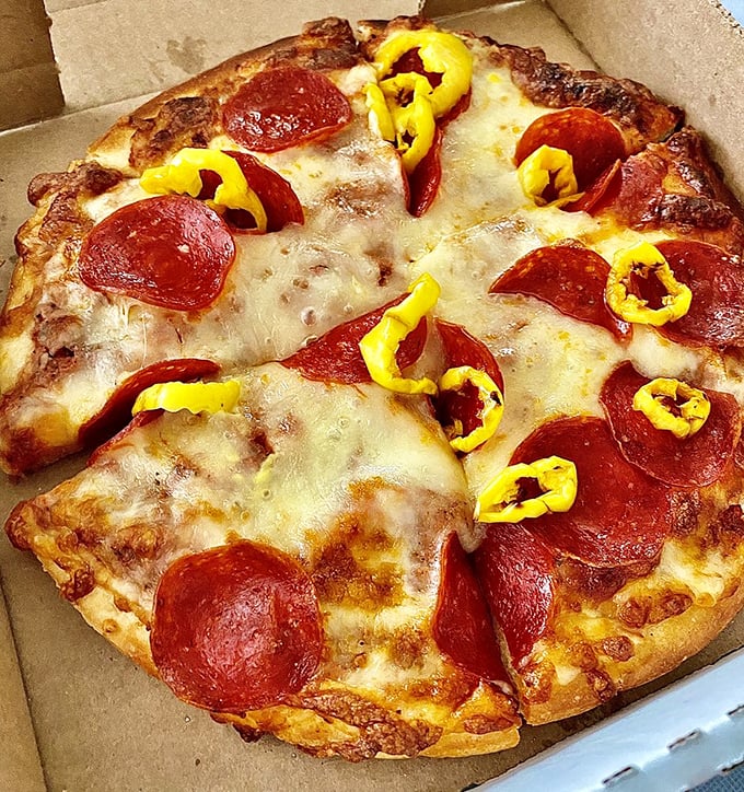 This isn't just pizza—it's a pepperoni and banana pepper manifesto, a declaration that simple ingredients done right still matter in this complicated world.