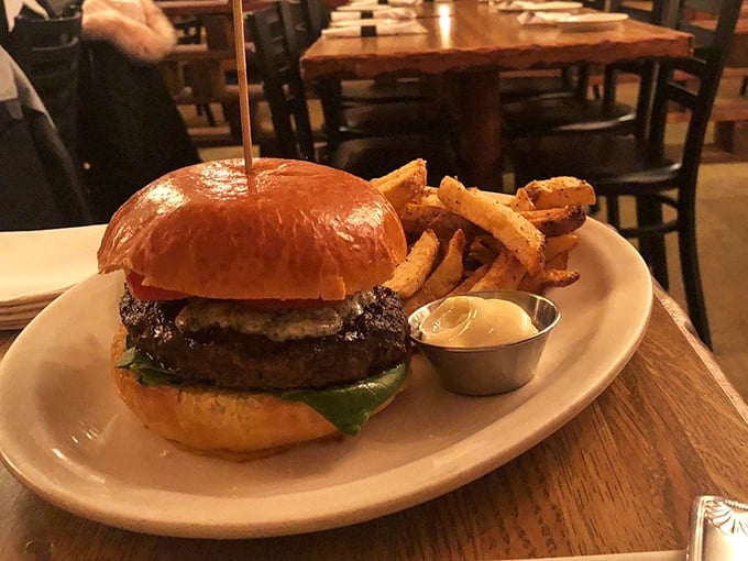 The burger arrives like a celebrity making an entrance—glistening, photogenic, and surrounded by a posse of hand-cut fries that aren't just an afterthought.