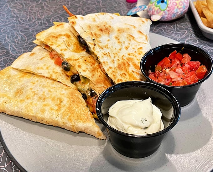 Quesadillas served with the holy trinity of Tex-Mex condiments – sour cream, salsa, and a story you'll tell friends about finding authentic flavor in unexpected places.