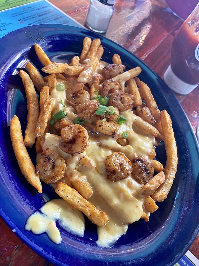 Crispy fries swimming in creamy sauce and topped with blackened shrimp—proof that sometimes the best seafood doesn't need the ocean.
