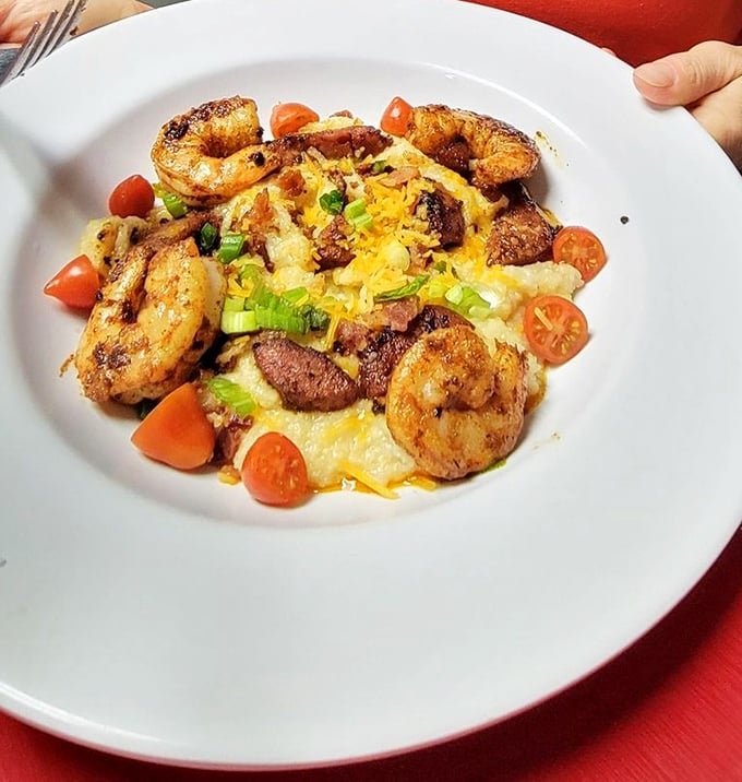 Shrimp and grits elevated to an art form—plump Gulf shrimp surrounding a creamy island of cheesy goodness, brightened with fresh tomatoes.