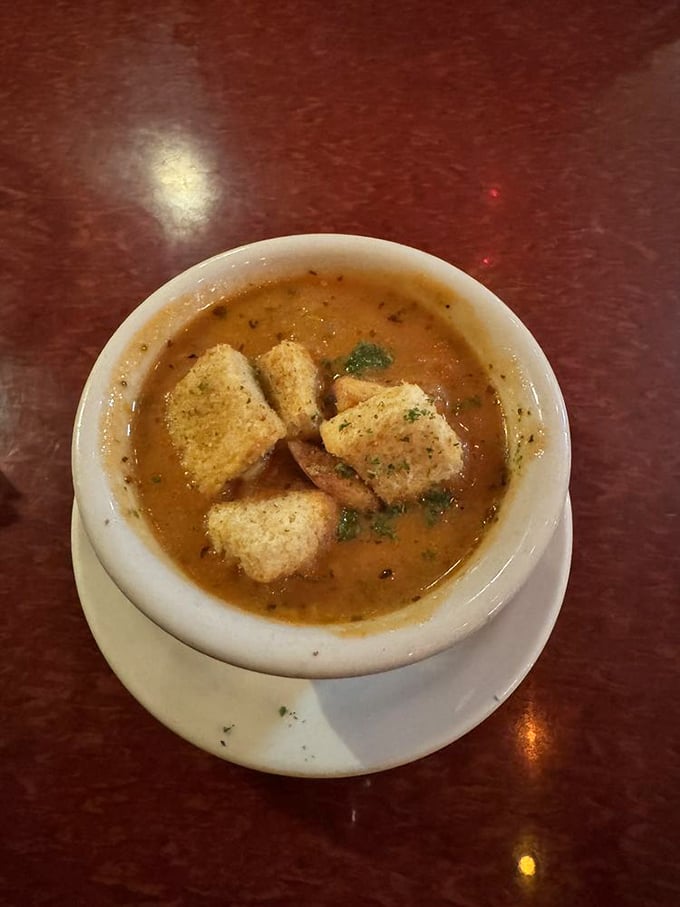A bowl of tomato soup that makes you question why you ever settled for the stuff from a can. Those croutons aren't just floating—they're making a statement.