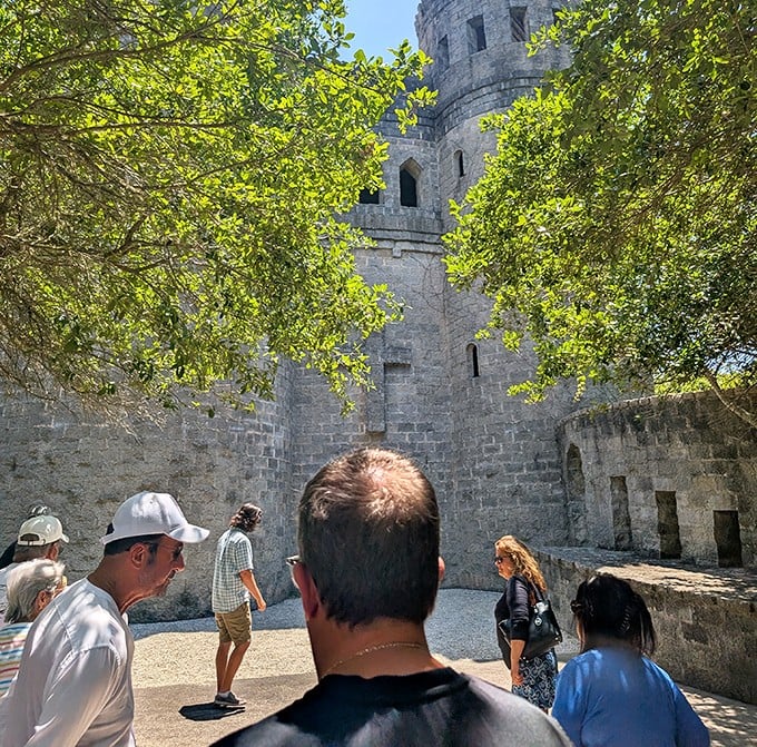 Visitors gather in the castle courtyard, dwarfed by towering walls that have witnessed countless Florida sunrises since their unlikely construction.