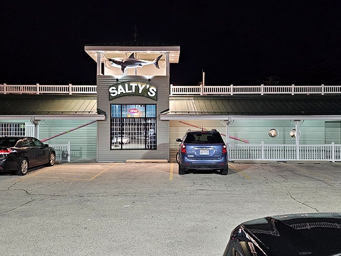 Salty's after dark—where a giant shark guards the entrance like the bouncer at Neptune's exclusive underwater club.