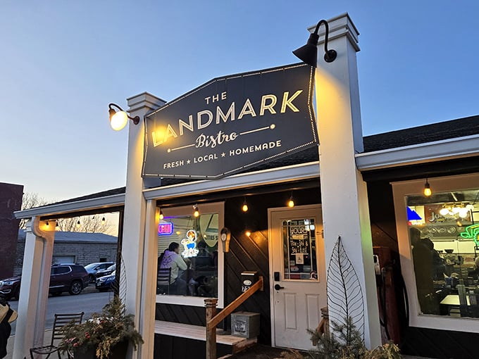 The Landmark Bistro glows with evening invitation – those white pillars framing a modern take on Iowa's steakhouse tradition.