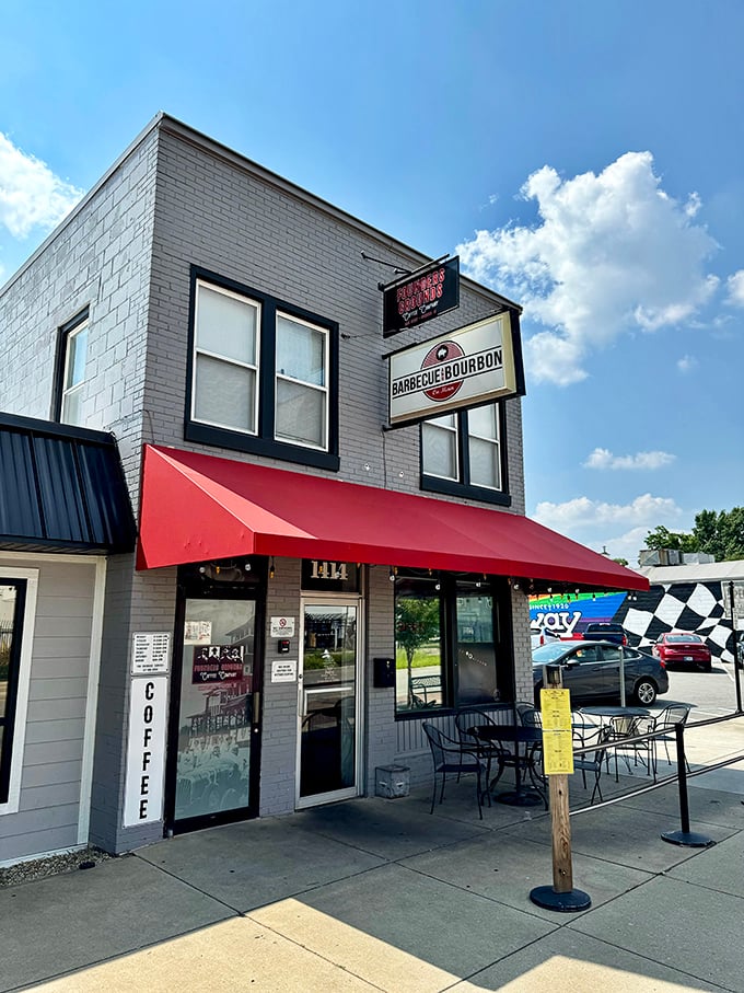 The gray brick building with bold signage stands like a delicious landmark – BBQ and bourbon, what more could you want?