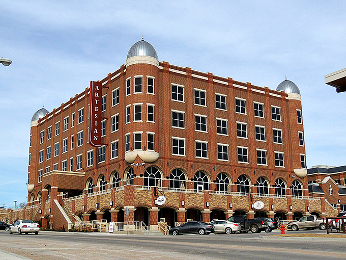 The Artesian Hotel rises like a red brick castle, promising luxury at hometown prices.
