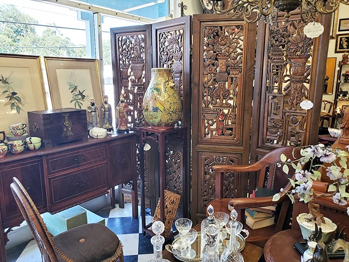 This intricate Chinese screen creates a dramatic backdrop for antique furniture, proving that sometimes the most beautiful room divider isn't on your smartphone. 