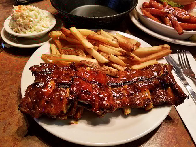 The rib rack arrives like meaty royalty on its throne of fries. That glistening sauce isn't just for looks—it's the barbecue equivalent of a perfect sunset.