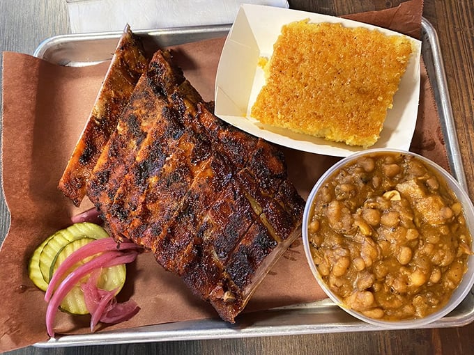Ribs with that perfect mahogany bark, cornbread that crumbles just right, and beans that have clearly been simmering with purpose. This is BBQ's holy trinity.