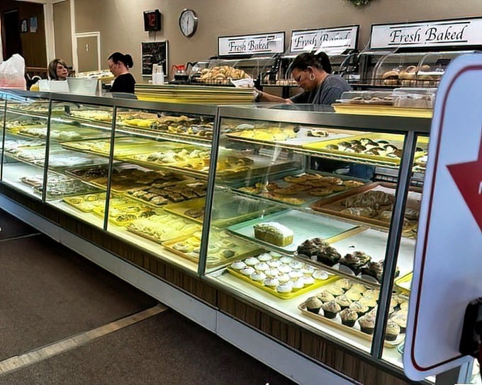 The bakery's display cases stretch like a treasure chest of carbohydrate wonders, each shelf offering a different path to happiness.