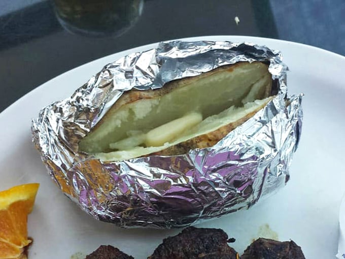 That foil-wrapped potato is hiding more butter and goodness than a dairy farmer's dreams.
