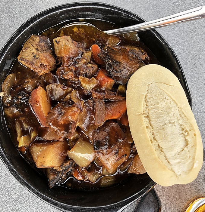 This isn't just beef stew; it's a hearty Irish hug in a bowl, with tender chunks of beef and vegetables swimming in rich gravy, served with bread for essential sopping.