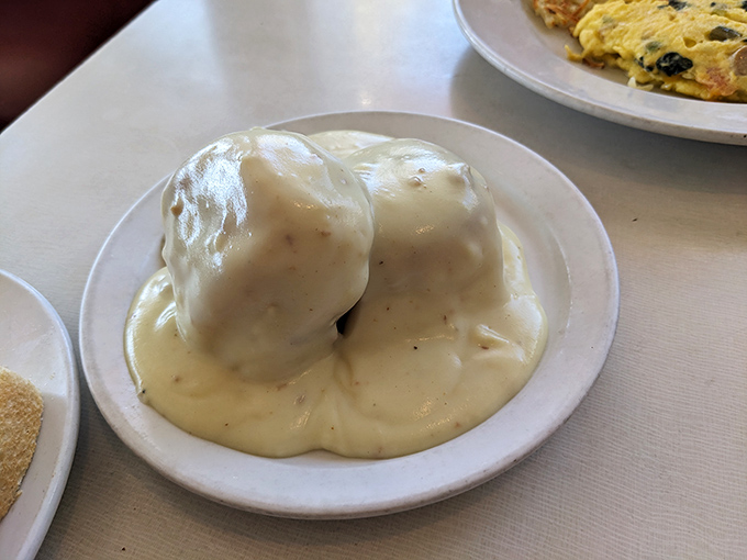 These biscuits and gravy look like they're wearing a warm, peppery blanket—comfort food in its purest, most huggable form.