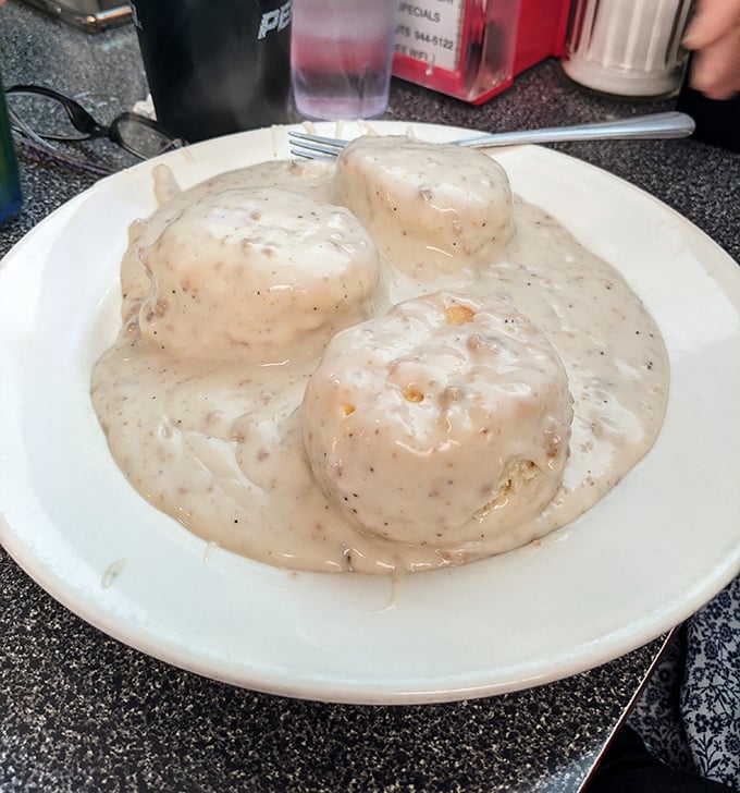 Biscuits swimming in sausage gravy—the kind of breakfast that requires a nap afterward and absolutely no apologies.