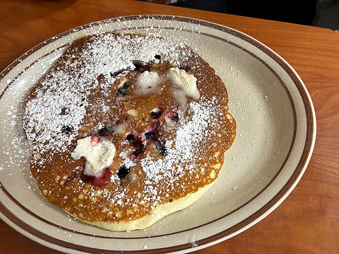 A blueberry pancake that's more treasure map than breakfast—each purple jewel leading you to another bite of fluffy, sweet perfection.