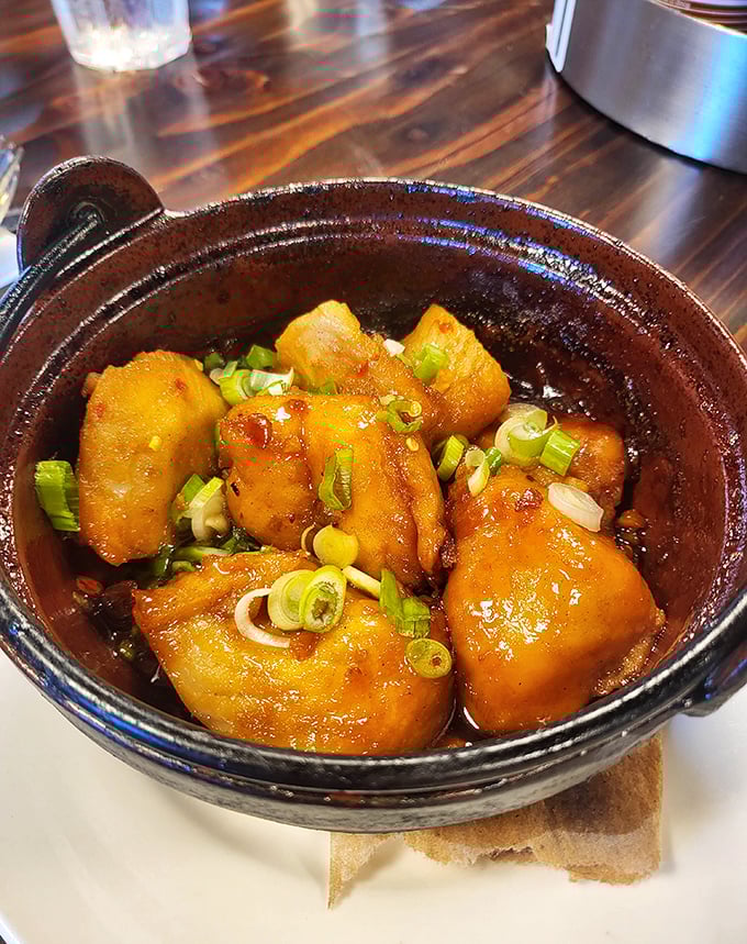 This clay pot of caramelized catfish isn't just dinner—it's a masterclass in slow-cooked perfection that would make your grandmother weep with joy.
