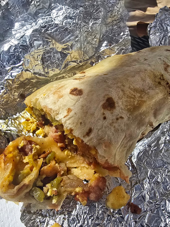 The breakfast burrito unwrapped reveals its glorious innards—eggs, potatoes, beans, and cheese bundled in a tortilla like a present to your taste buds.