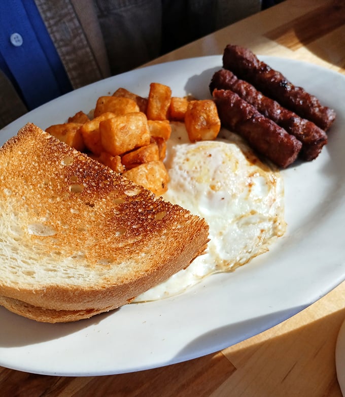 The breakfast trinity: golden toast, perfectly fried eggs, and sausage links that snap when bitten—proof that simple pleasures remain life's most reliable comforts.