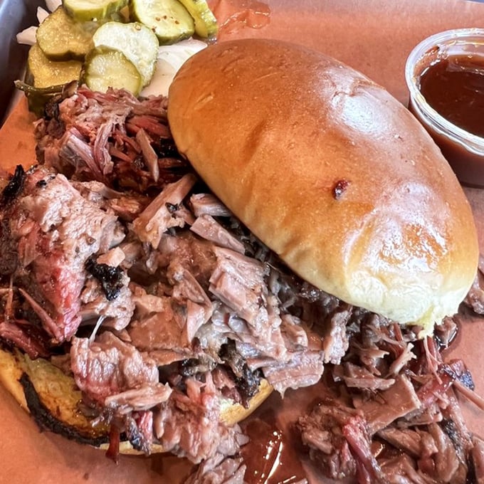 The sandwich that launched a thousand napkins – tender brisket spilling from its bun like it's making a jailbreak toward your taste buds.