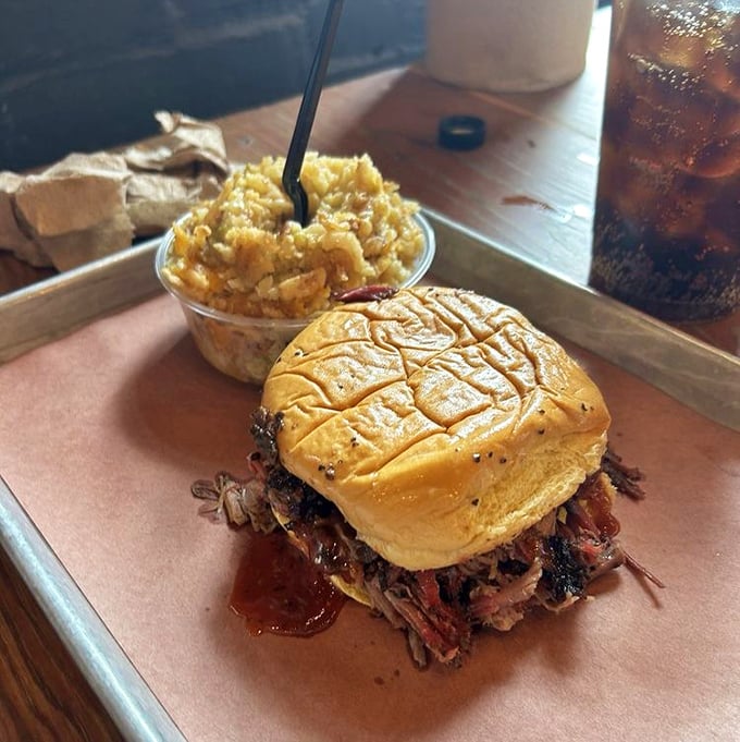 The brisket sandwich—a study in beautiful simplicity. Buttery bun, pile of smoky meat, and just enough sauce to make you question whether you need it at all.