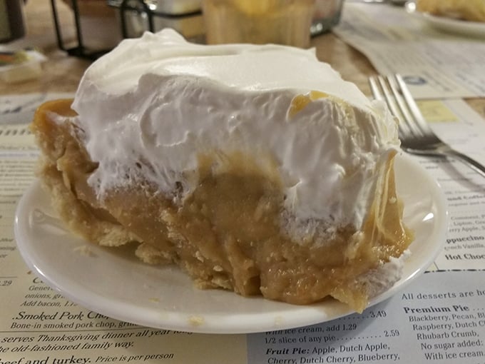Butterscotch pie reaching for the heavens with its towering meringue – proof that sometimes the best things in life are simple, sweet, and slightly excessive.