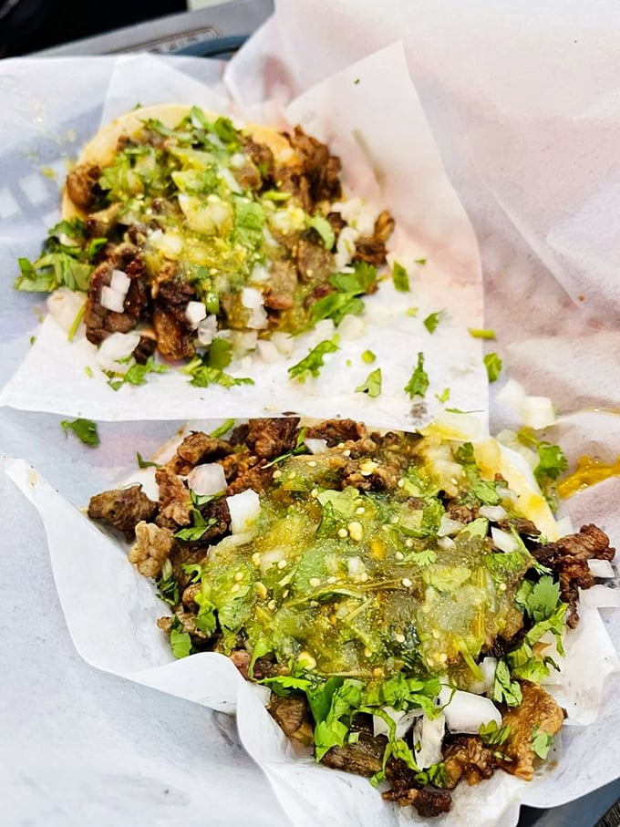 Carne asada tacos dressed with cilantro, onion, and salsa verde—proof that sometimes the simplest combinations create the most profound flavors.