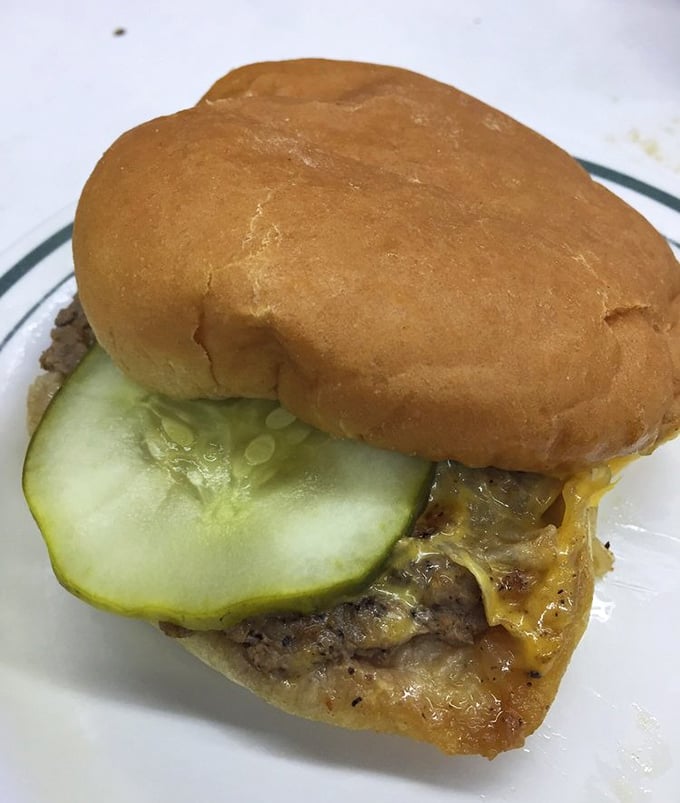 This isn't just a cheeseburger—it's a masterclass in simplicity with its pickle slice peeking out like it knows something you don't yet.